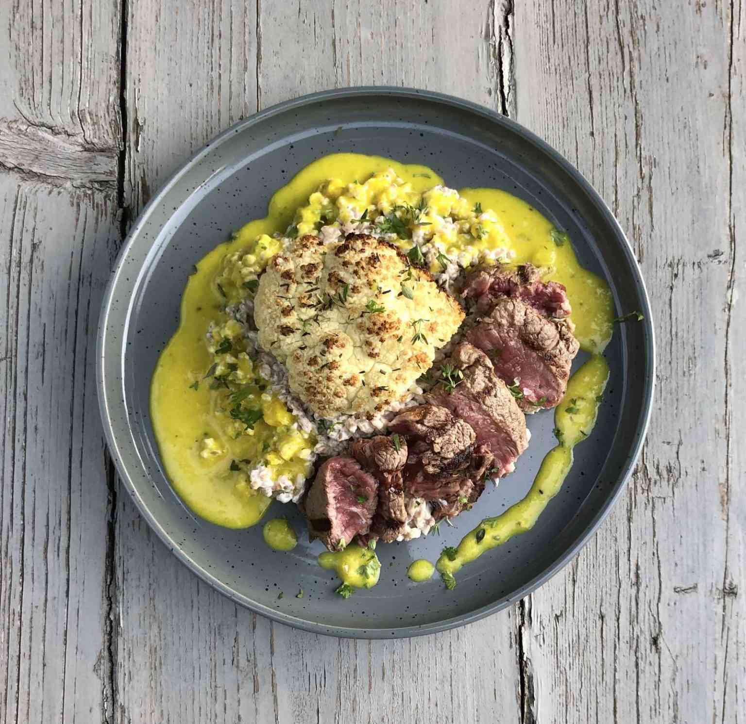 Geroosterde bloemkool met kruiden, spelt, ribeye steak en picklessaus ...